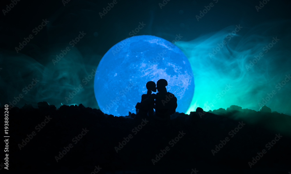 Silhouette of couple kissing under full moon. Guy kiss girl hand on ...