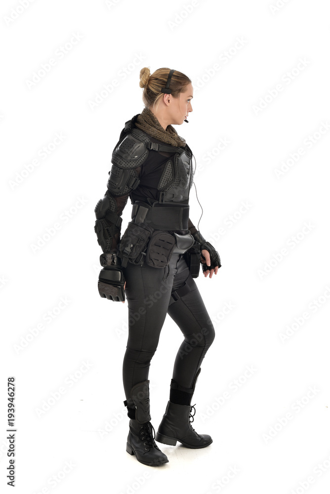 full length portrait of female soldier wearing black tactical armour ...
