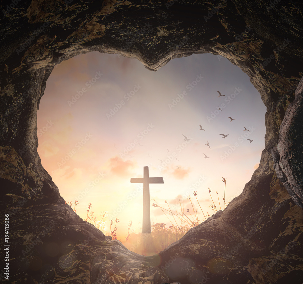 Easter Religious concept: Heart shape of empty tomb stone with the cross over meadow sunrise ...