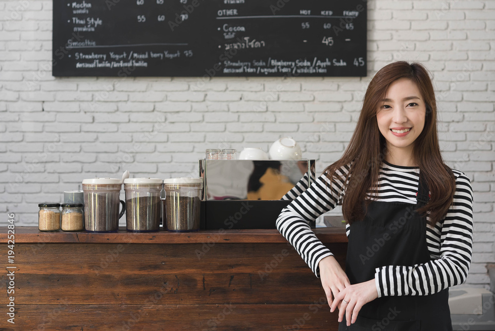 Young woman owner of a cafe stand in front of coffee counter, young ...