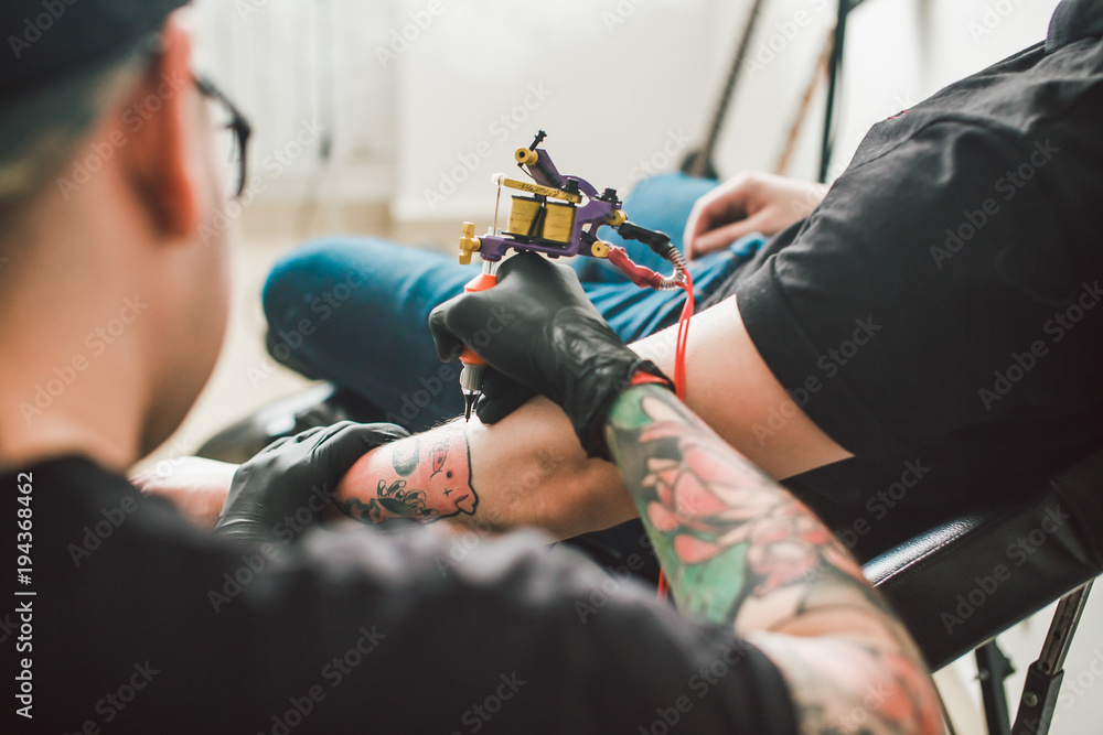 tattoo machine make drawing on male hand.Tattooing process,master ...