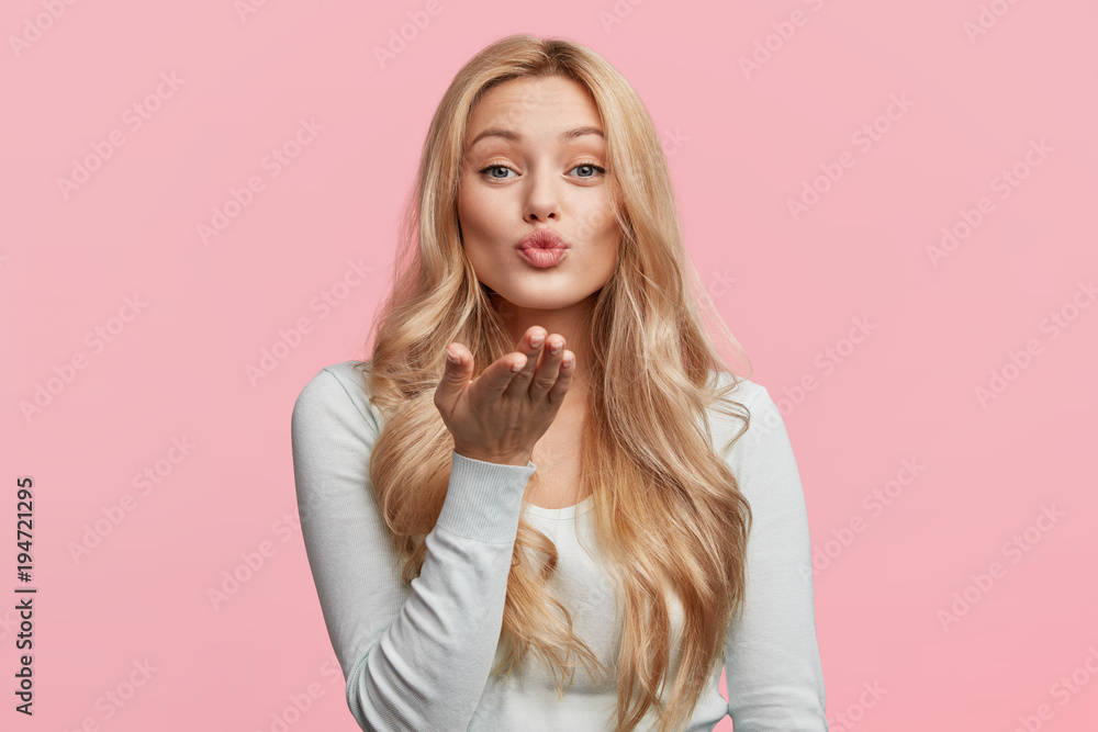 Pretty blonde woman blows passionate kiss into camera, expresses her ...