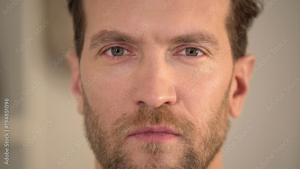 Serious angry man looking into camera, annoyed male face close-up ...