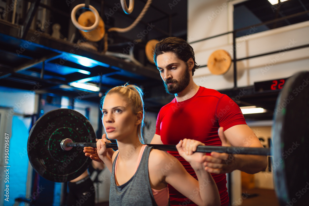 Motivated young slim athletic fitness woman standing and doing squad ...