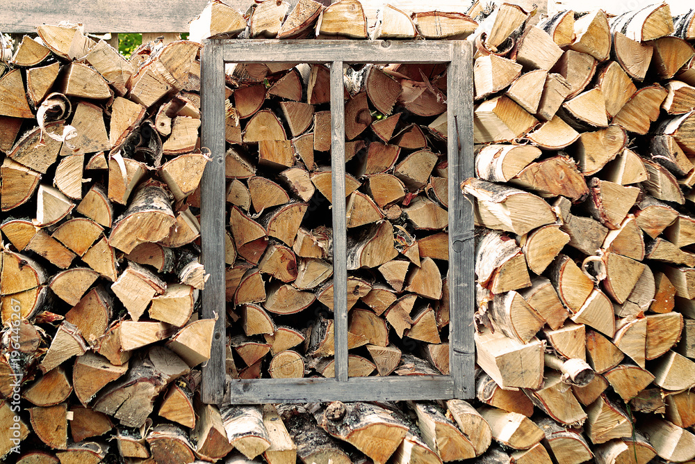Old window frame on stacked firewood pile. Cross section of the timber ...