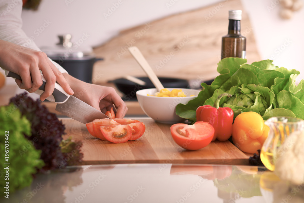 Close Up of human hands cooking vegetable salad in kitchen on the glass ...