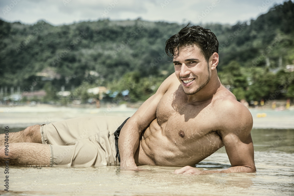 Handsome young man laying down on a beach in Phuket Island, Thailand ...