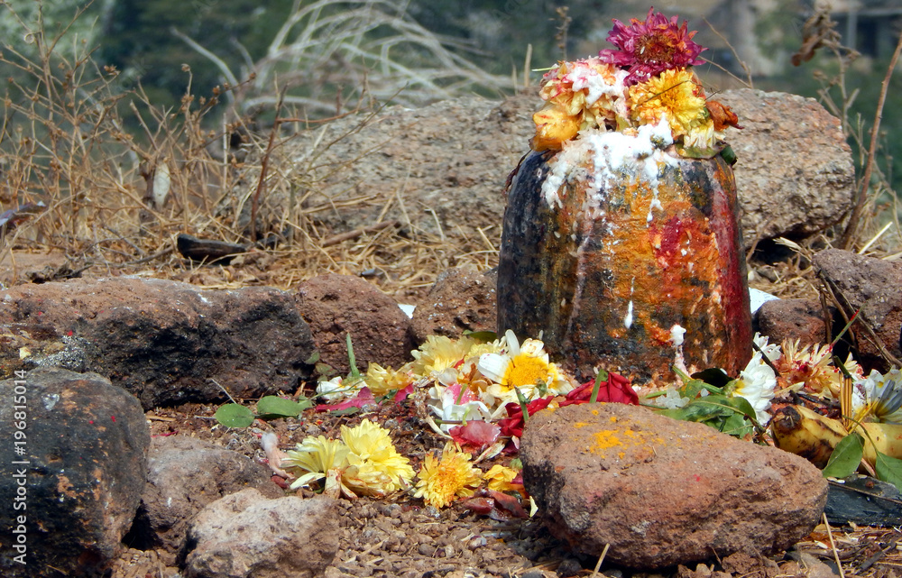 Hindu People offer prayers or do puja to stone ancient carved linga ...