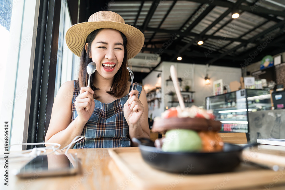 Young asian woman eating icecream, cake, waffle or unhealthy food at ...