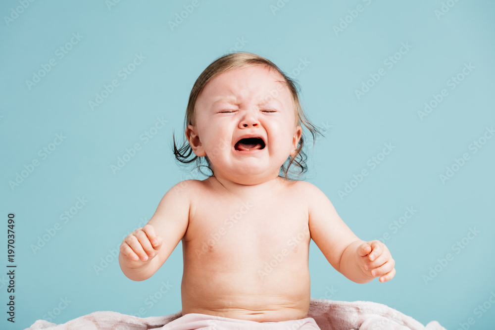 Sad baby sitting down and crying. Stock Photo | Adobe Stock