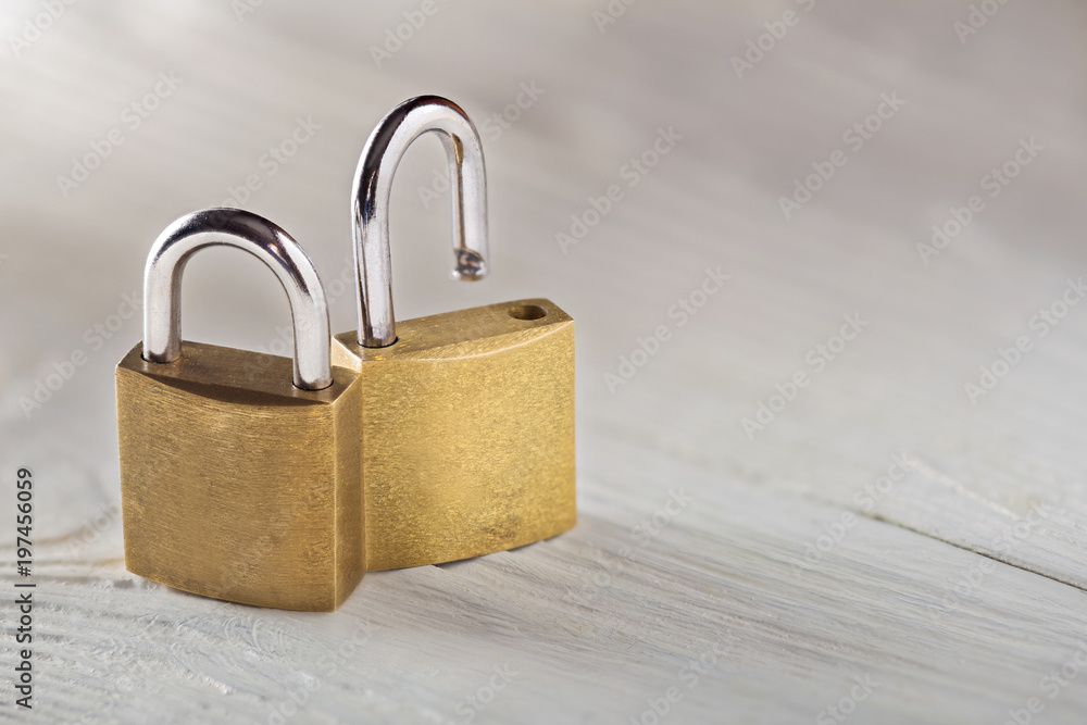 Two padlock, lock and unlock, with silvered keys on white wooden ...