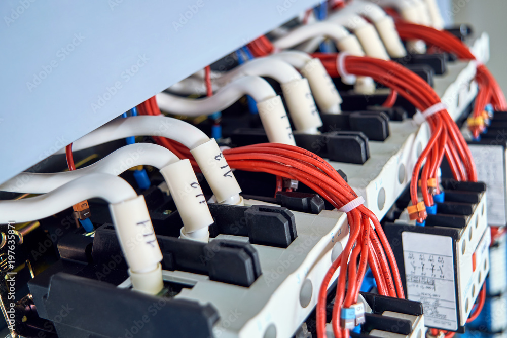 A number of magnetic starters and connected electrical wires in the ...