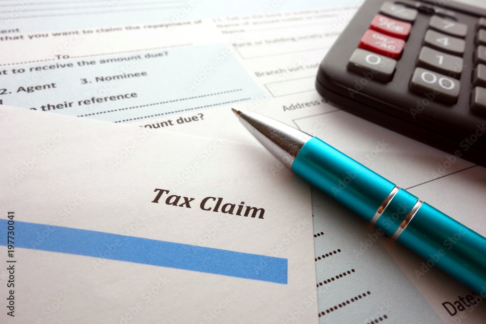 Tax claim form, pen and calculator, paperwork Stock Photo | Adobe Stock