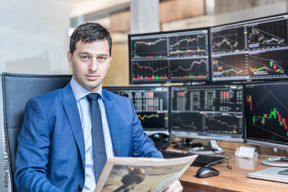 Business portrait of confident stocks broker holding a business ...
