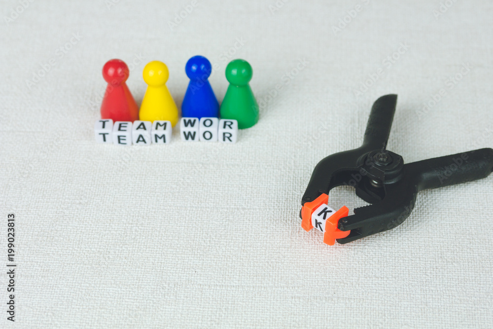 Team work concept - Figures in the line and an clamp tool as symbol for ...