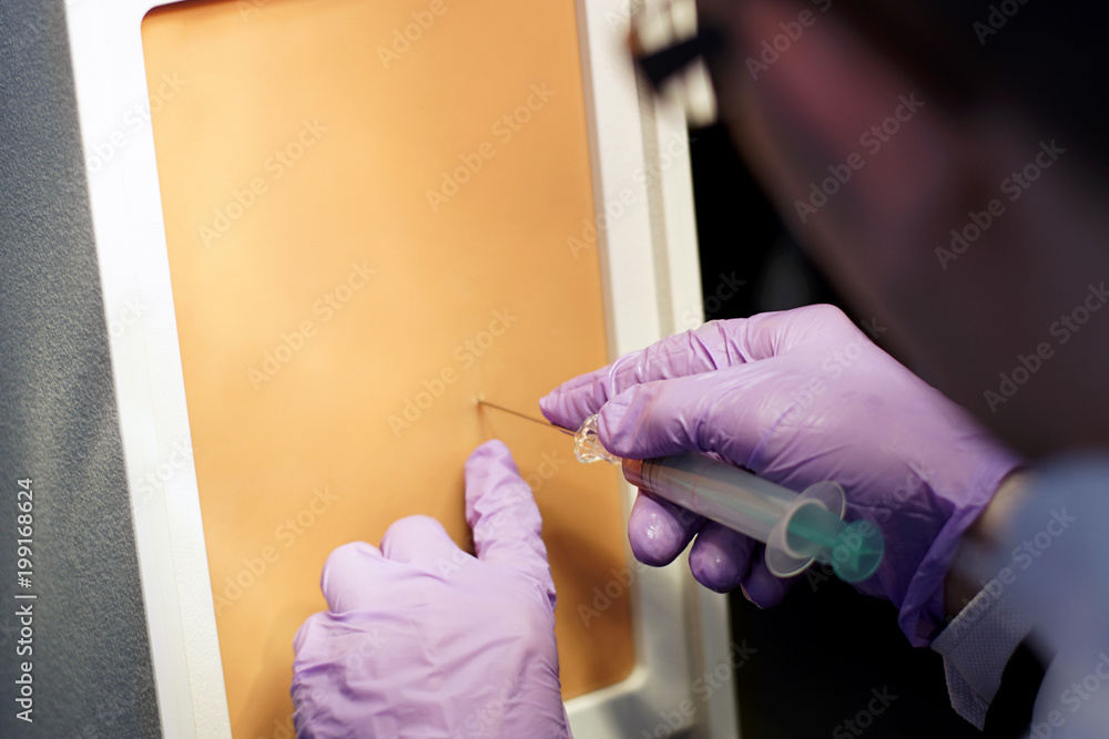 Doctor in gloves making injection with a syringe for puncture ...