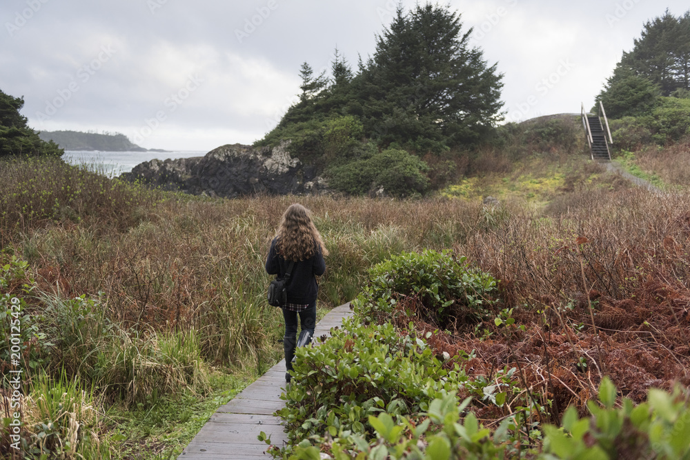 Girl walking on boardwalk at coast, Cox Bay, Pettinger Point, Pacific ...