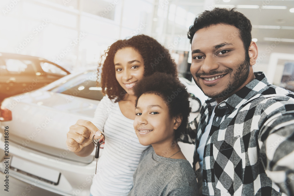 African american family at car dealership. Mother, father and son are ...
