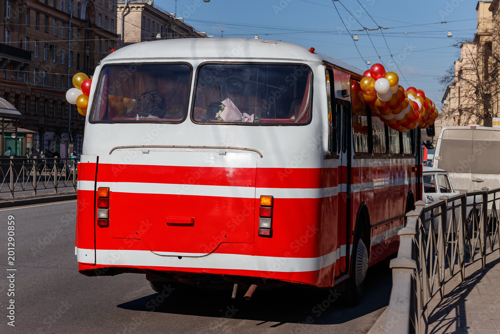 The old bus stops at the bus stop. Retro bus decorated with balloons in ...