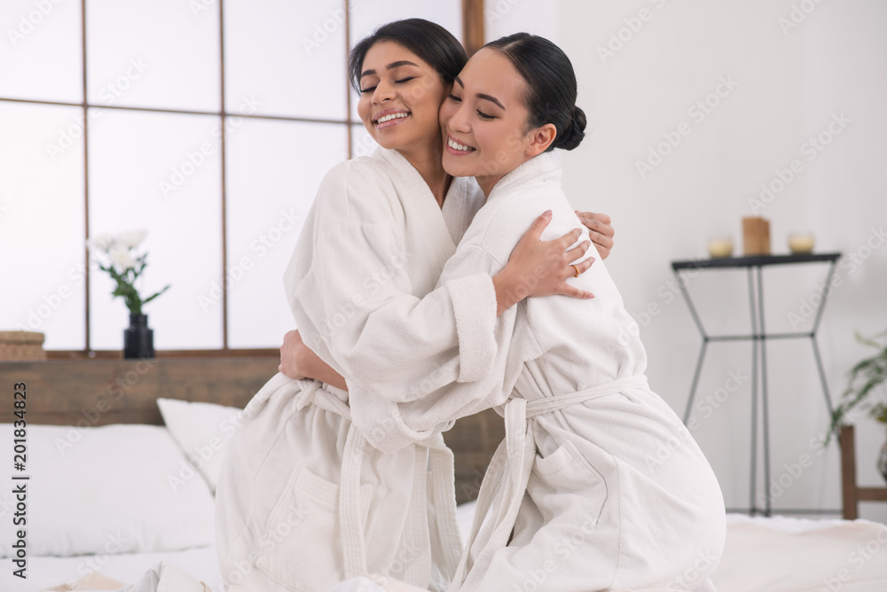 LGBT community. Positive lesbian couple hugging each other while being ...