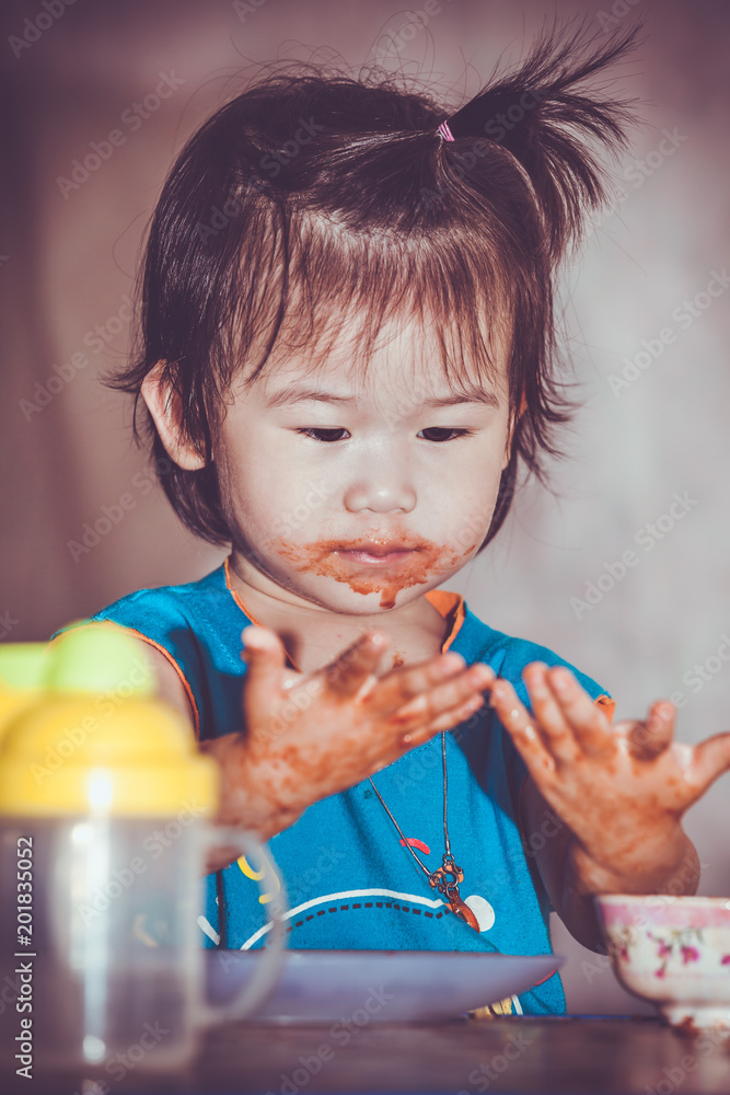 Child eating with a stained face. Do it yourself concept. Vintage tone ...