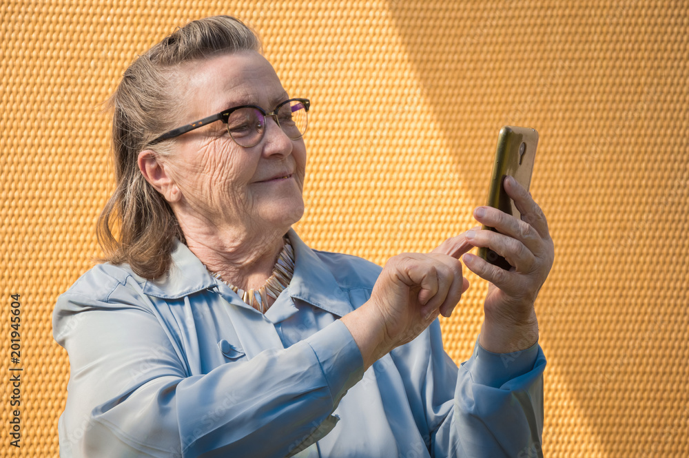 portrait of old lady, grandmother makes selfie outdoors at sun day ...