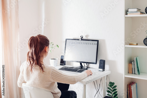 Workspace of female office employee. Woman works on computer in light ...