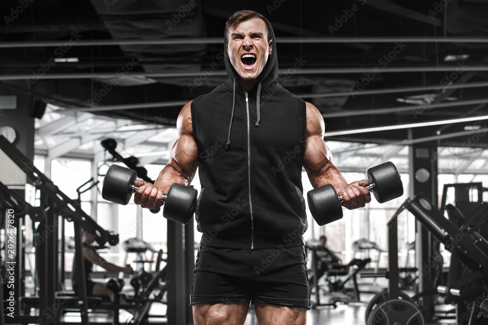 Muscular man working out in gym doing exercises, strong male ...