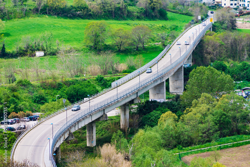 Passing cars on a bridge, a transport bridge in the middle of hills and ...