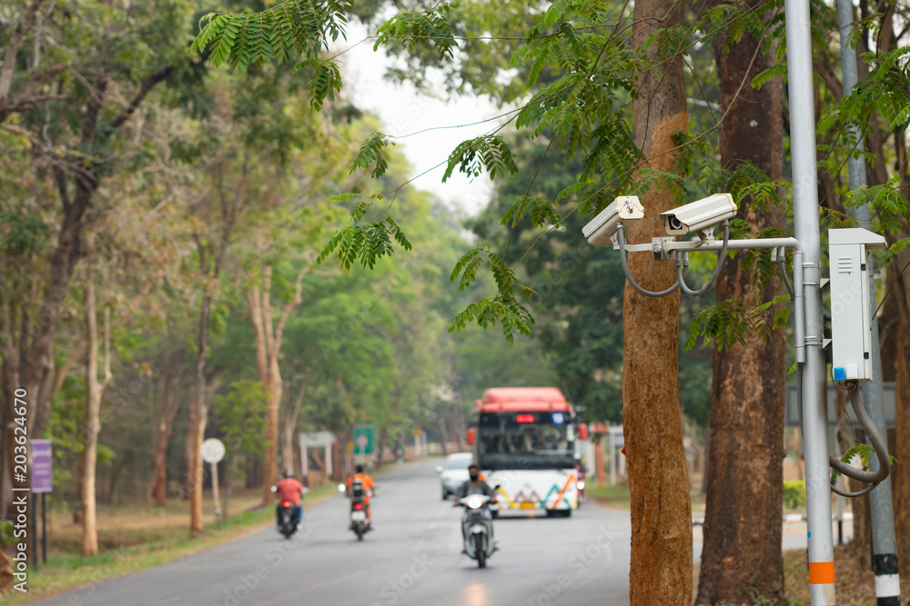 Security CCTV camera installed at public area near road over blur ...