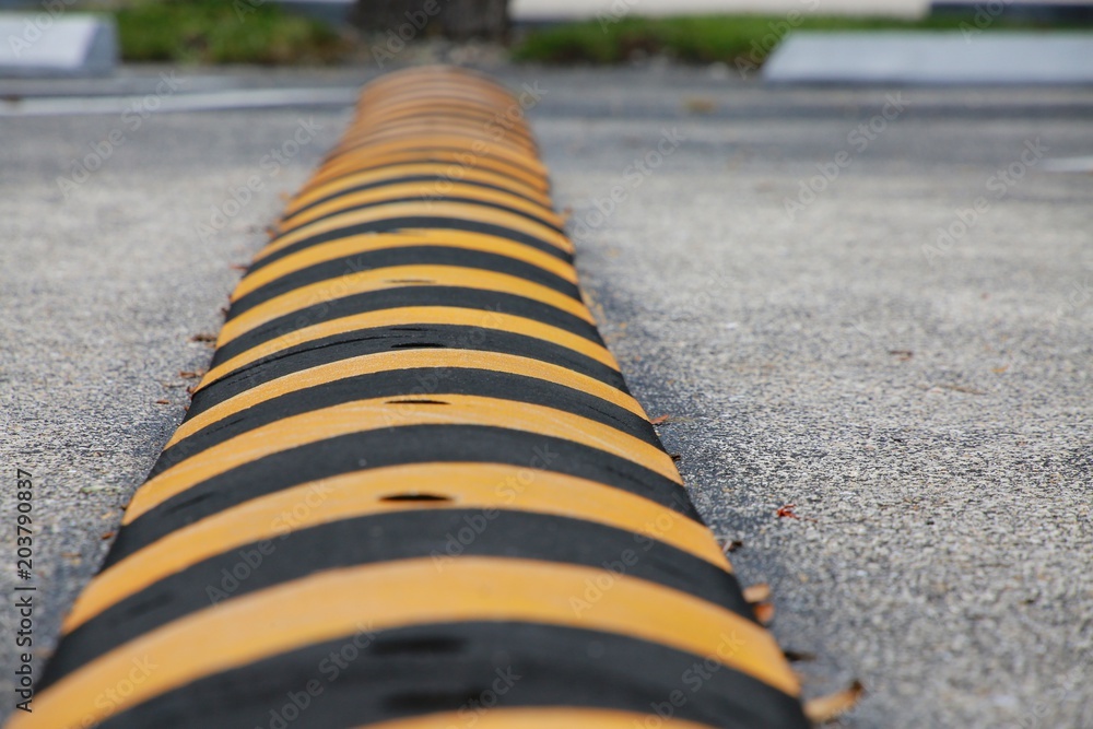 Yellow and Black Striped Speed Bump with Nails Visible in Parking Lot ...