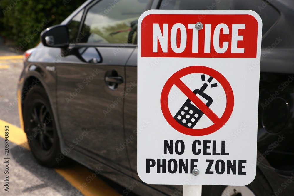 Red Black and White Notice No Cell Phone Zone Sign with a Black 4-Door ...