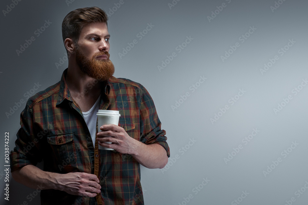 Dramatic light studio shot of young caucasian bearded stylish man with ...