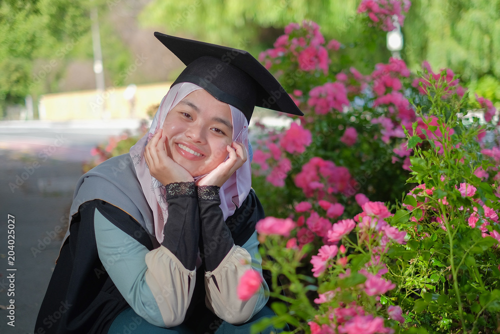 Beautiful female Muslim wearing a convocation robe and posed in ...