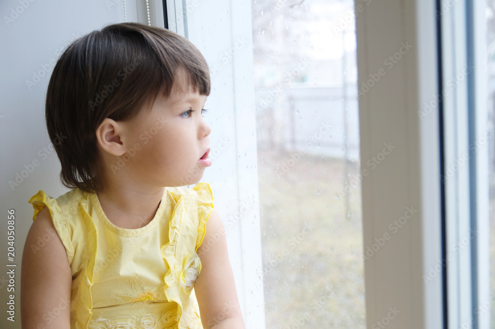 little girl looking out the window longing for some sunshine. curiosity ...