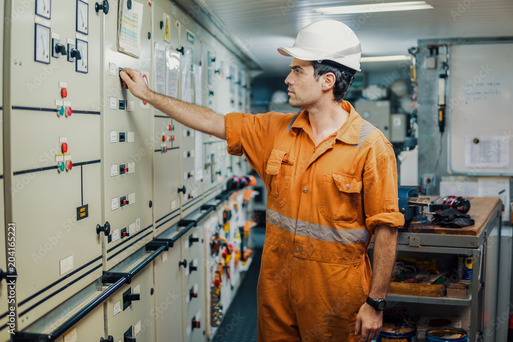 Marine engineer officer starts or stops main engine of ship in engine ...