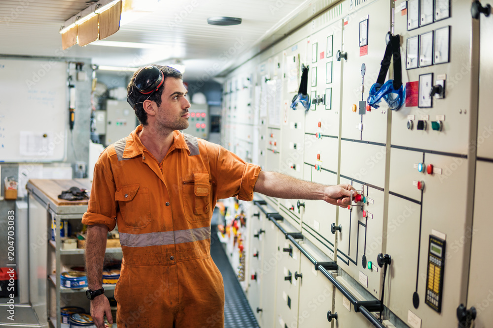 Marine engineer officer controlling vessel engines and propulsion in ...