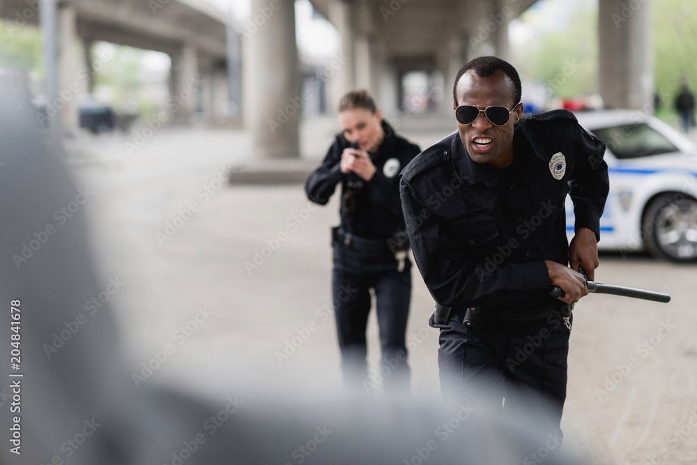 multiethnic police officers running for thief Stock Photo | Adobe Stock