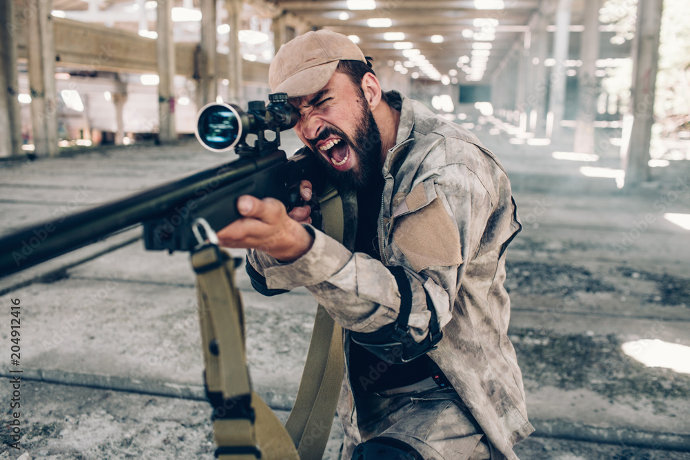 Horizontal view of military soldier screaming and yelling. He is taking ...