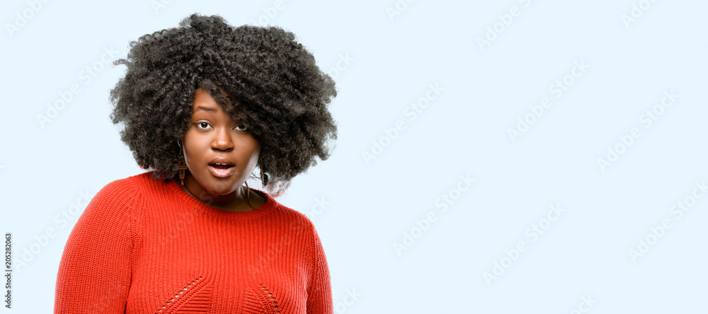 Beautiful african woman scared and surprised cheering expressing wow ...