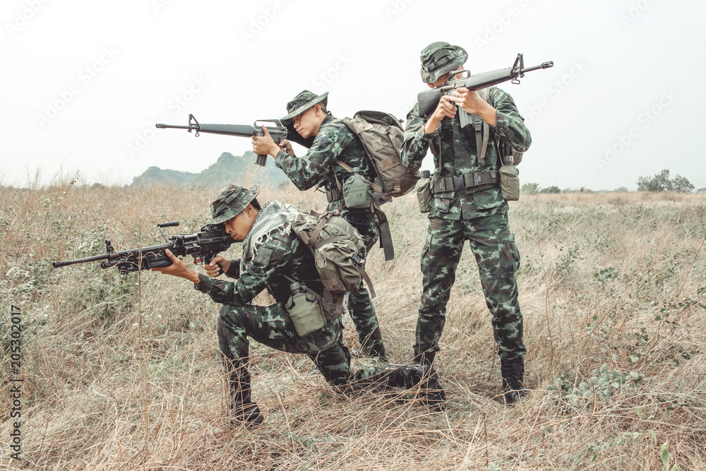 Soldier ready his weapon. Standing and kneeing holding their assault ...