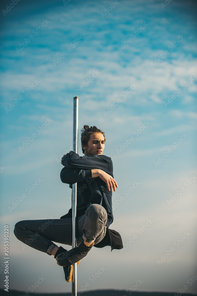 Foto de Stock Athletic guy make acrobatic elements on pylon. athletic ...