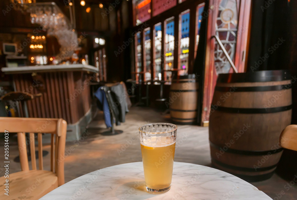 Beer with lemon for visitor of bar with vintage wooden furniture and ...