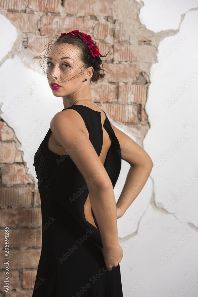 Sexy young girl in a long black dress with heels, with red lips and an ...