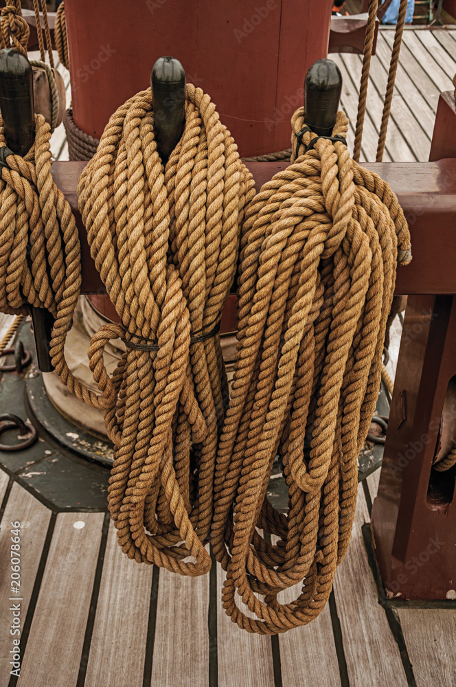 Rolled rope and pulleys supported on the central mast of a sailing ship ...