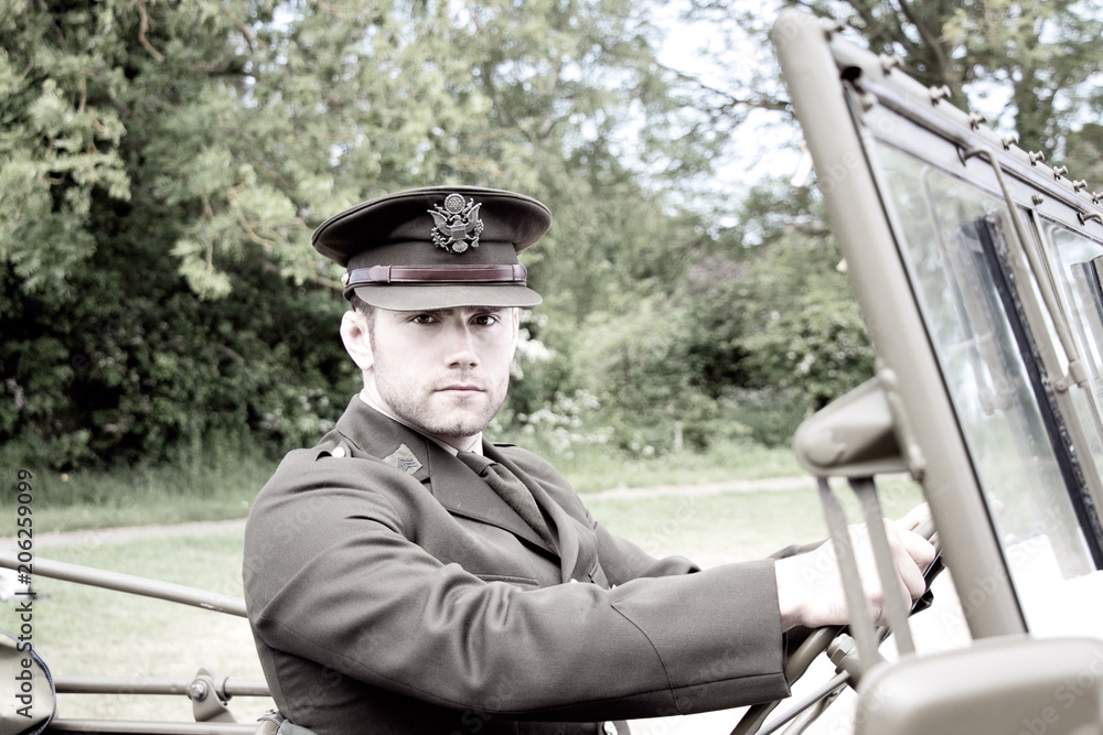 Handsome American WWII GI Army officer in uniform riding Willy Jeep ...