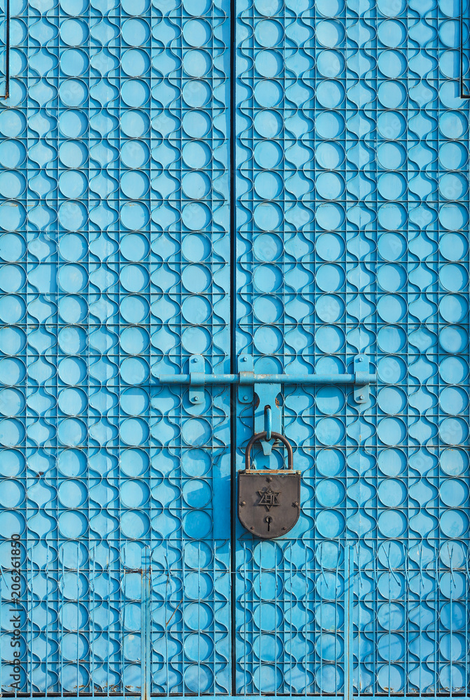 Big metal gate of blue color with patterns, are closed on the huge ...