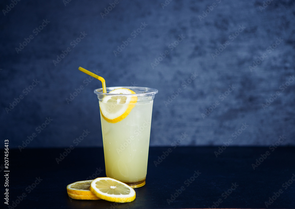 Lemon lemonade in the plastic cup on the black background Stock Photo ...