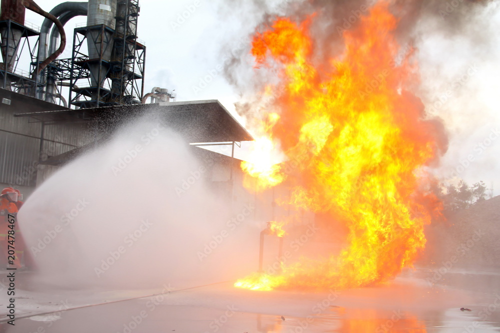 fireman using water and extinguisher to fighting with fire flame in an ...