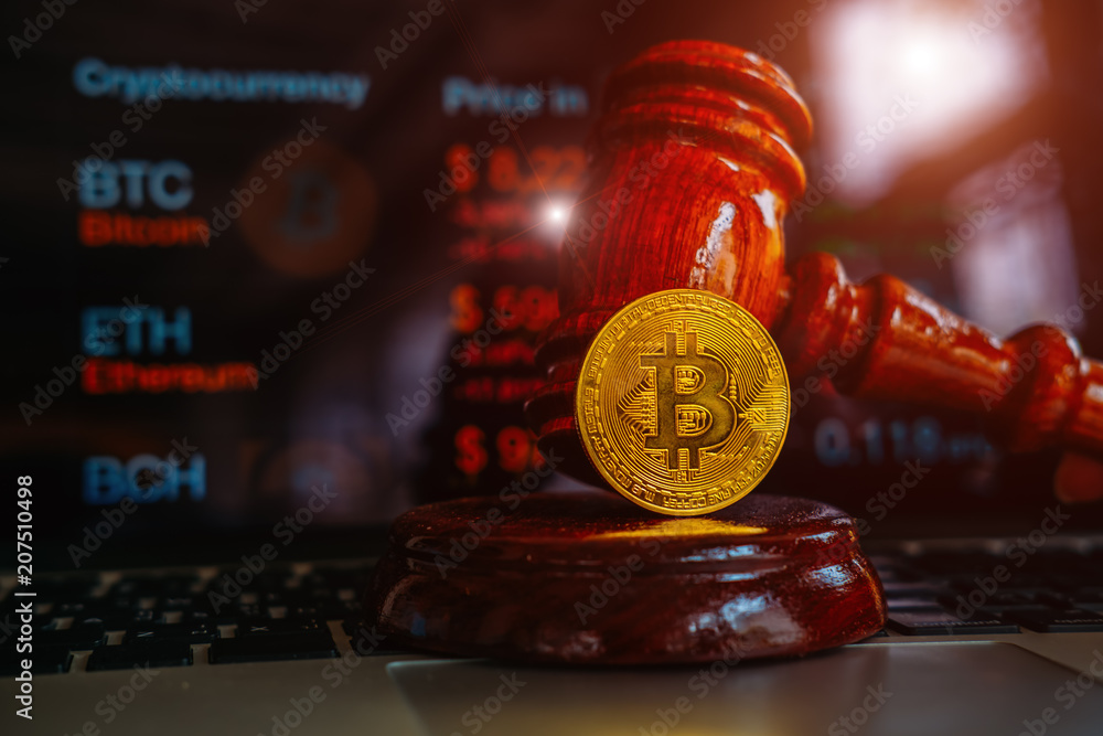 Law or auction gavel and bitcoins on a wooden desk, dark background ...